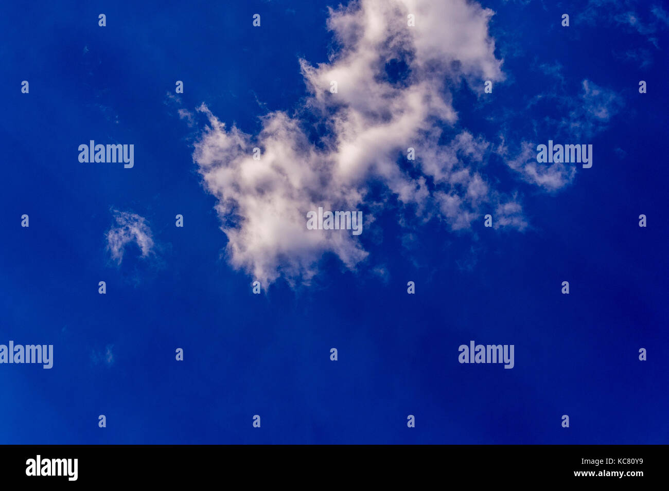 Deep blue sky with scattered clouds Stock Photo - Alamy