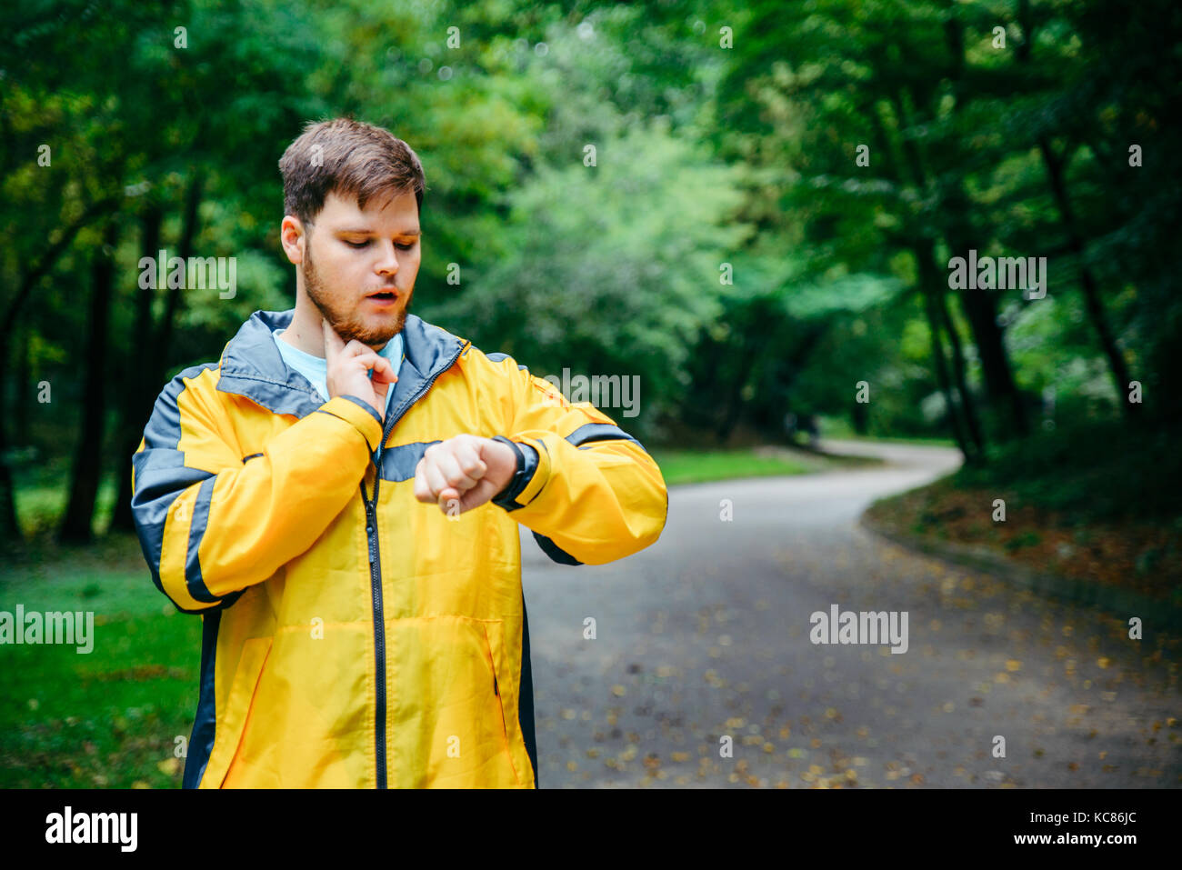 man measuring his pulse while running in autumn park Stock Photo - Alamy
