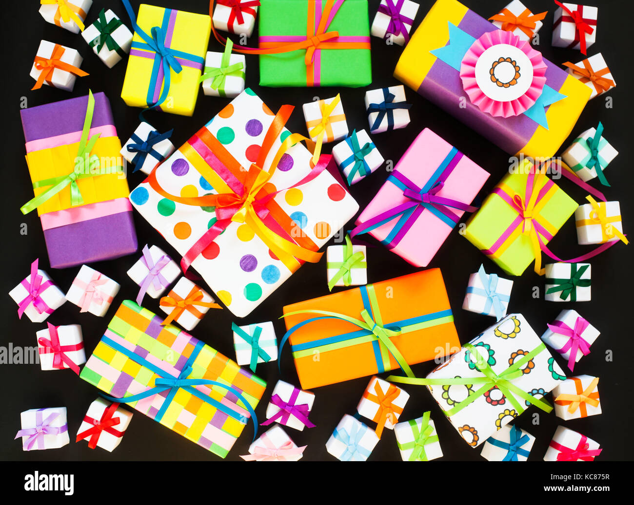 There are many different beautiful colored gifts with colorful ribbons ...