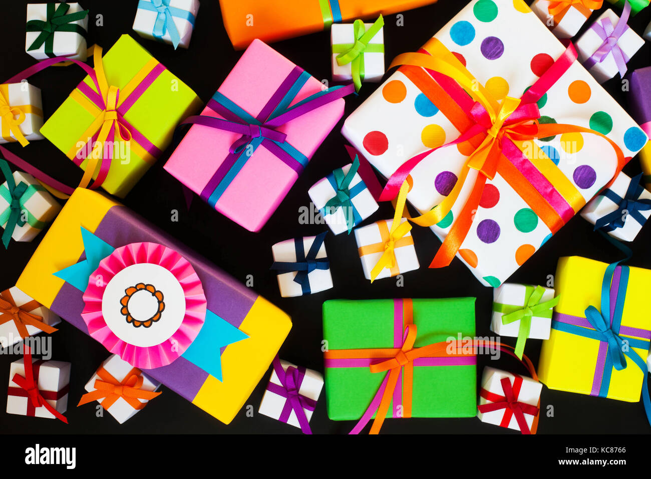 There are many different beautiful colored gifts with colorful ribbons ...