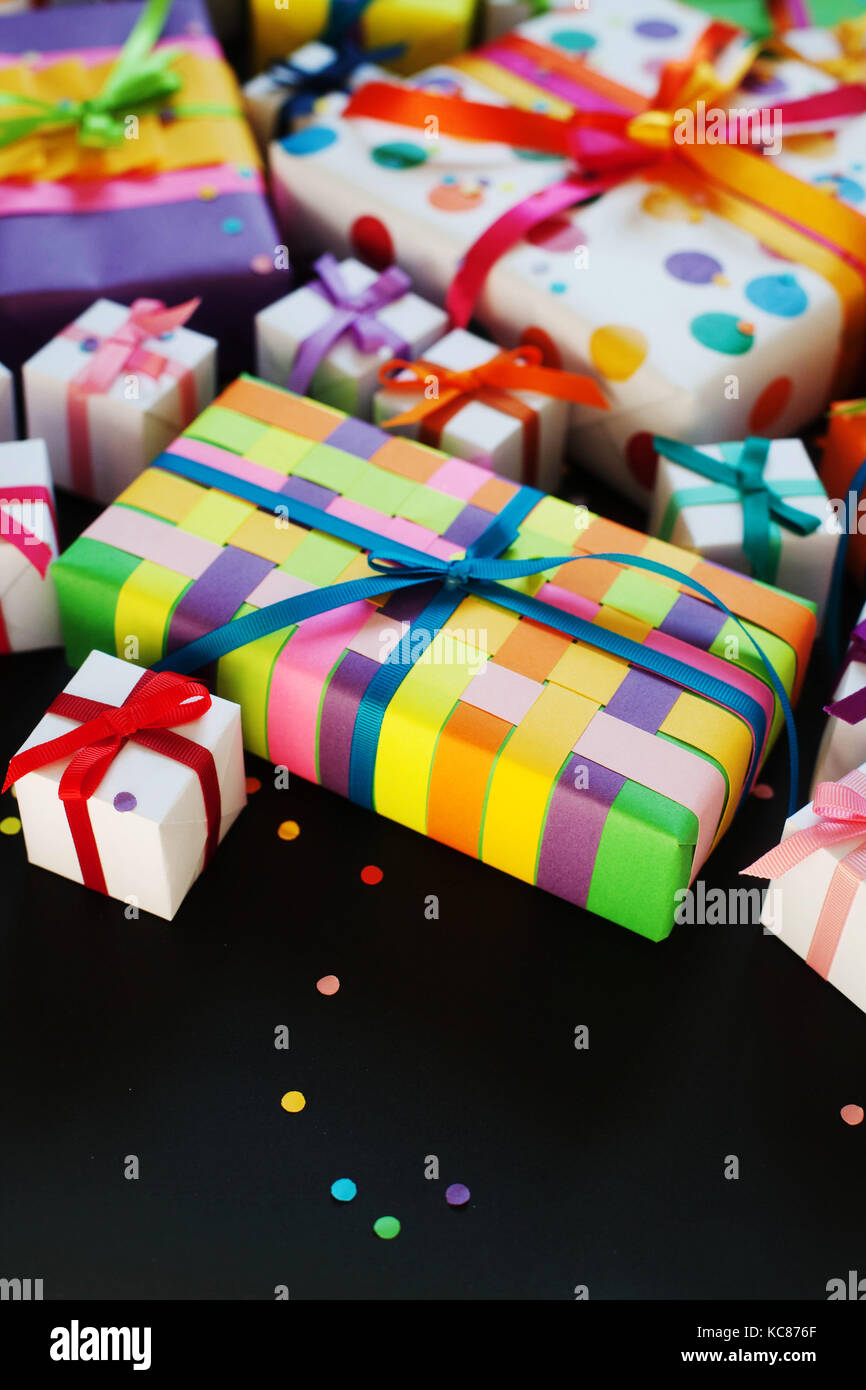 There are many different beautiful colored gifts with colorful ribbons ...
