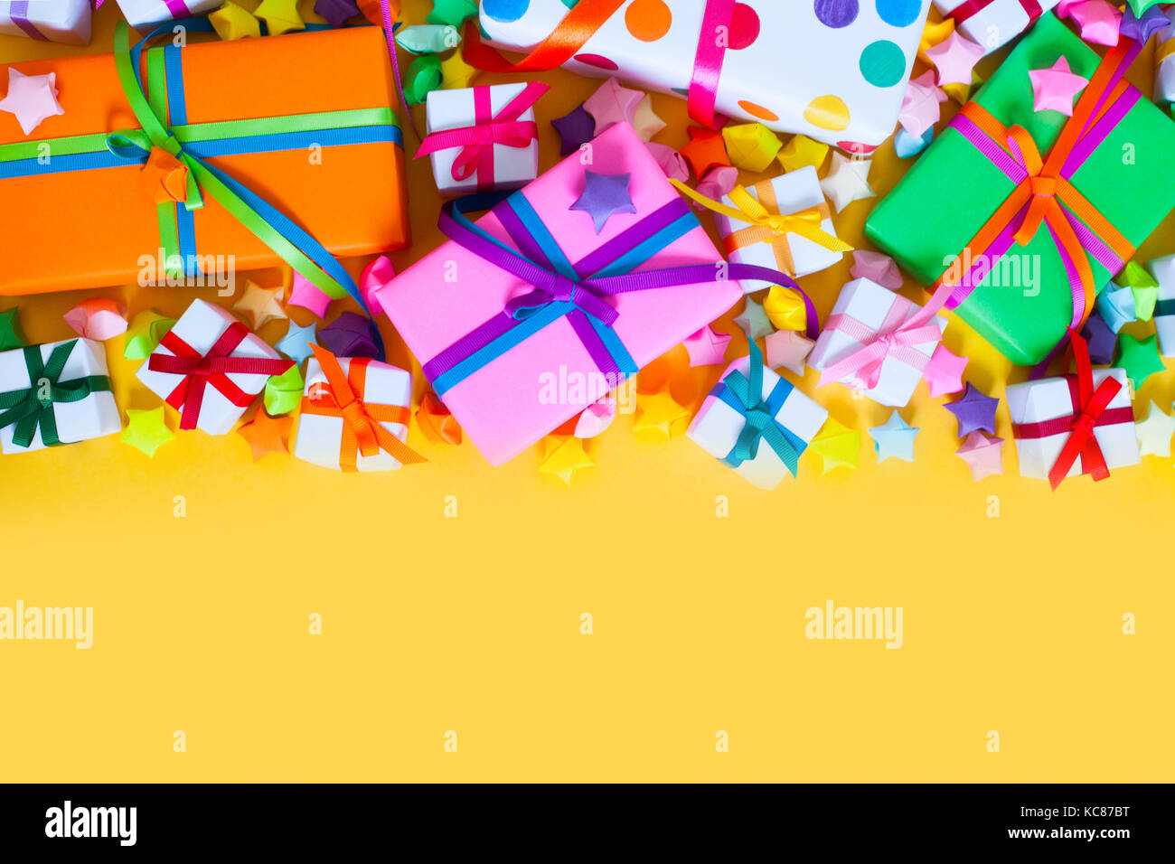 Colored gift boxes with colorful ribbons. Yellow background. Gifts for ...