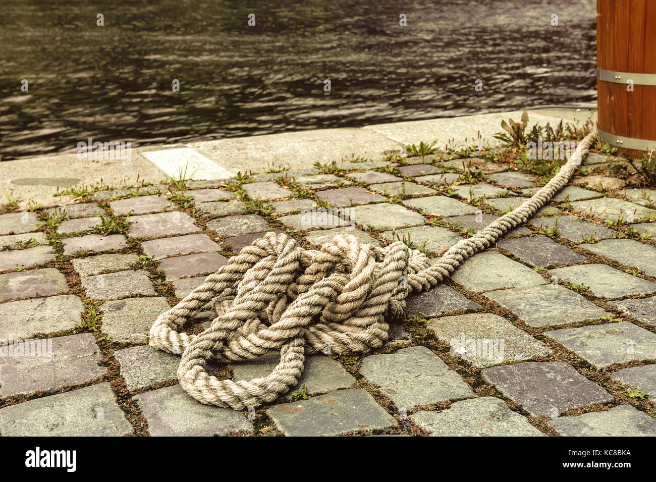 Marine rope tied knot lying on the sidewalk near the pier Stock Photo ...