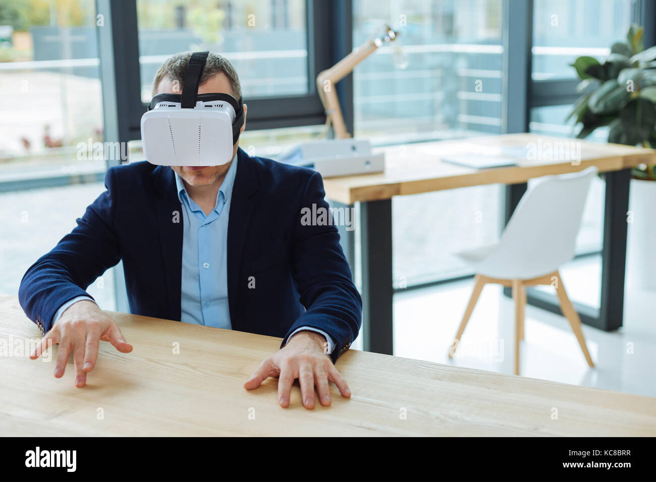 Pleasant handsome man putting his hands on the table Stock Photo - Alamy