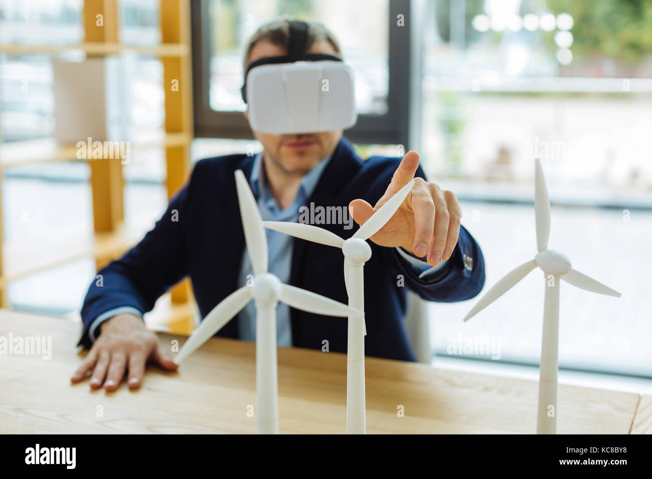 Nice handsome man touching the windmill model Stock Photo - Alamy