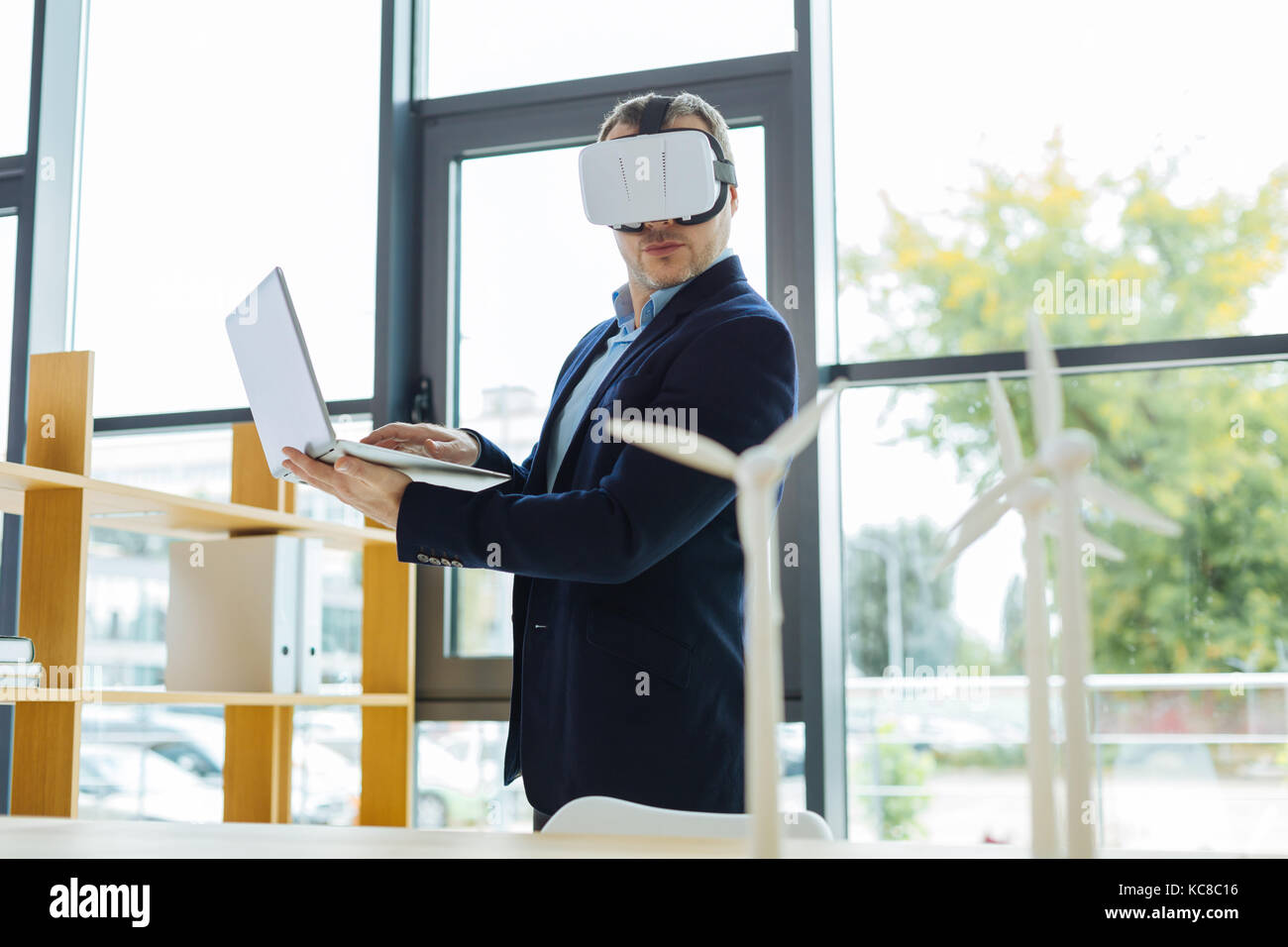 Serious smart man holding a laptop Stock Photo - Alamy
