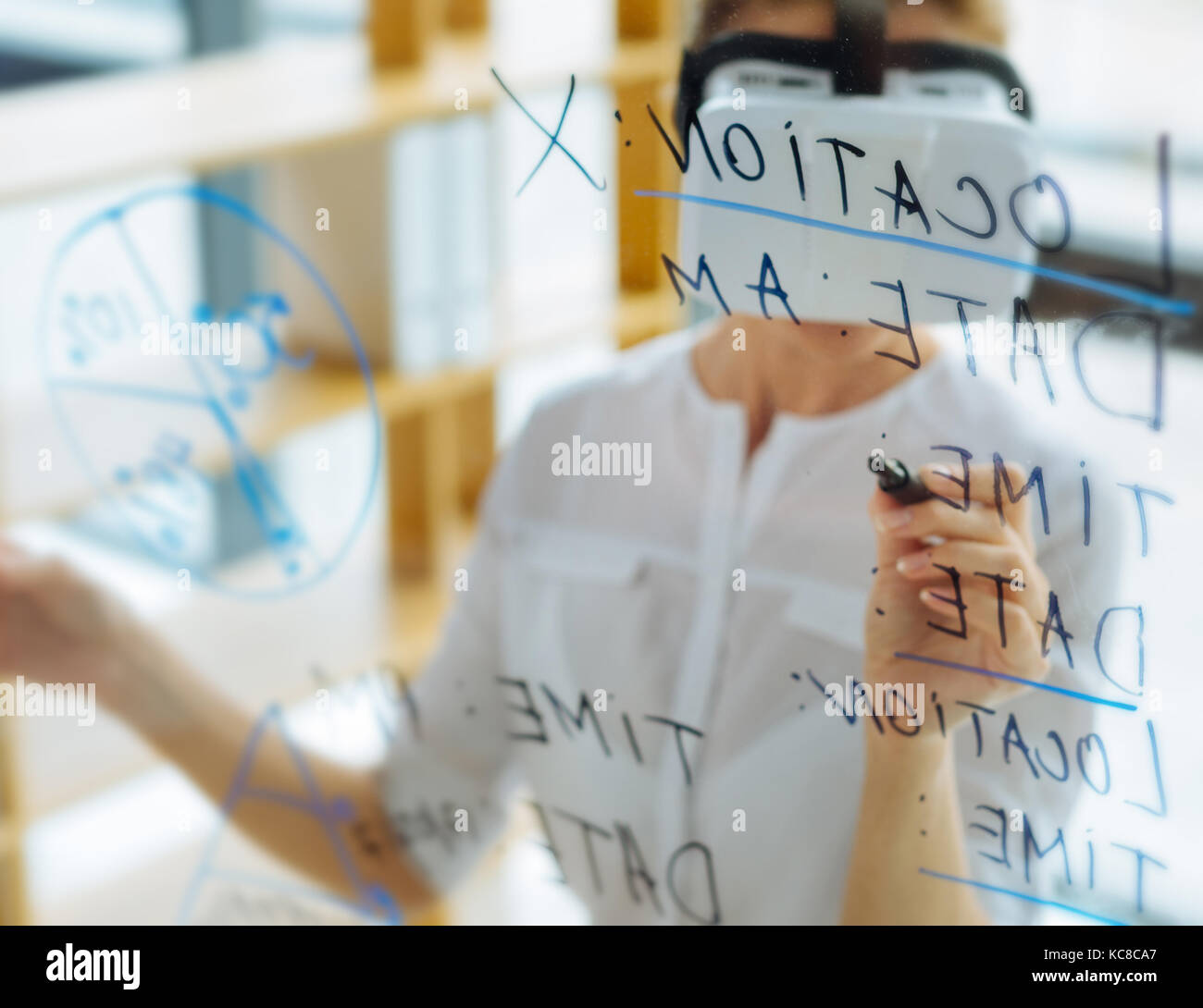 Positive nice woman writing on the glass screen Stock Photo - Alamy