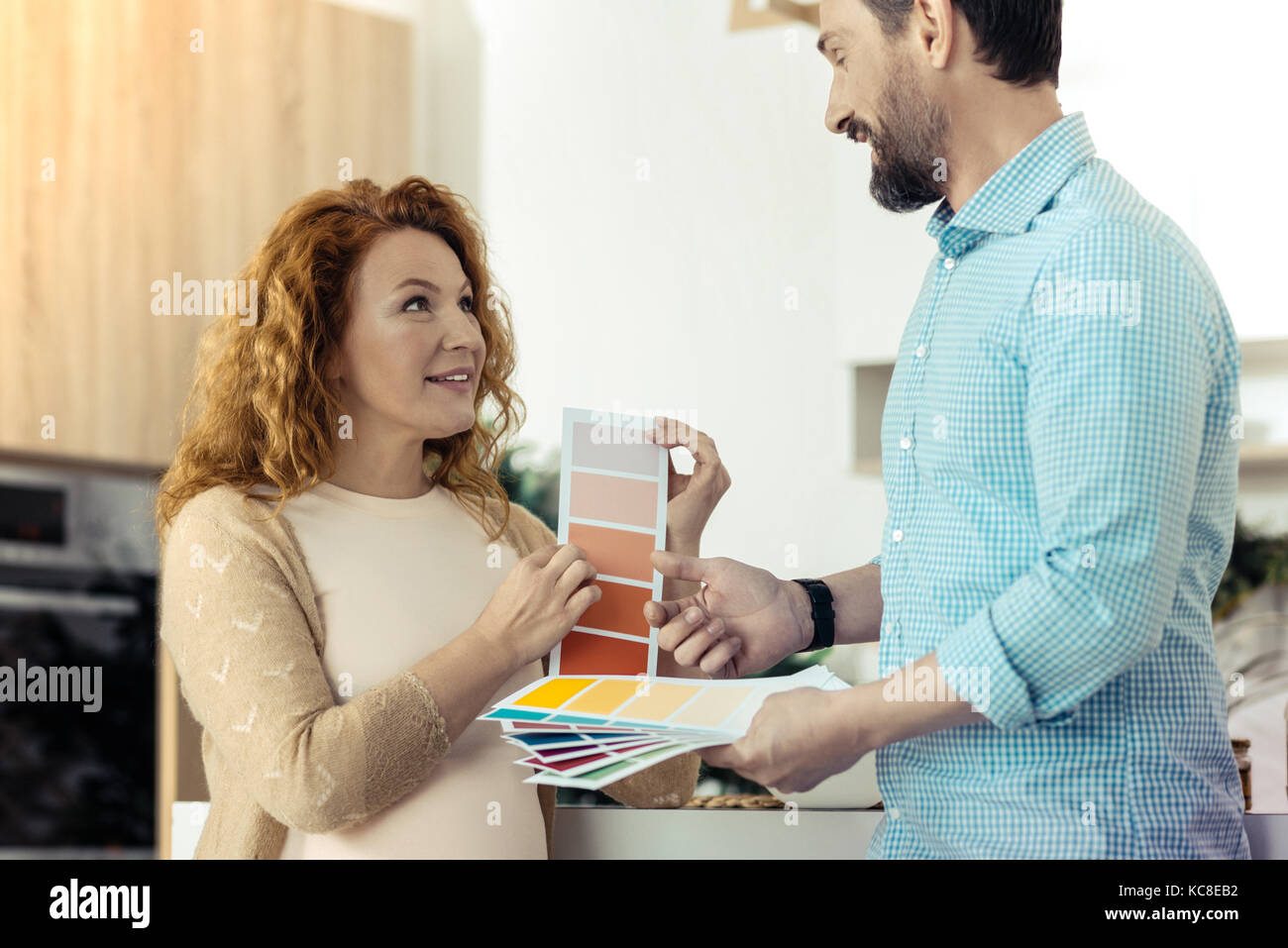 Optimistic family choosing the color design for a new flat Stock Photo ...