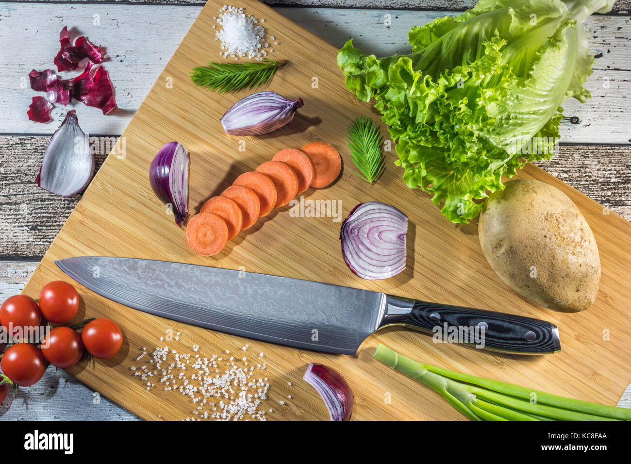 Big chef knife with healthy food - vegetables, onion, salad, potato ...