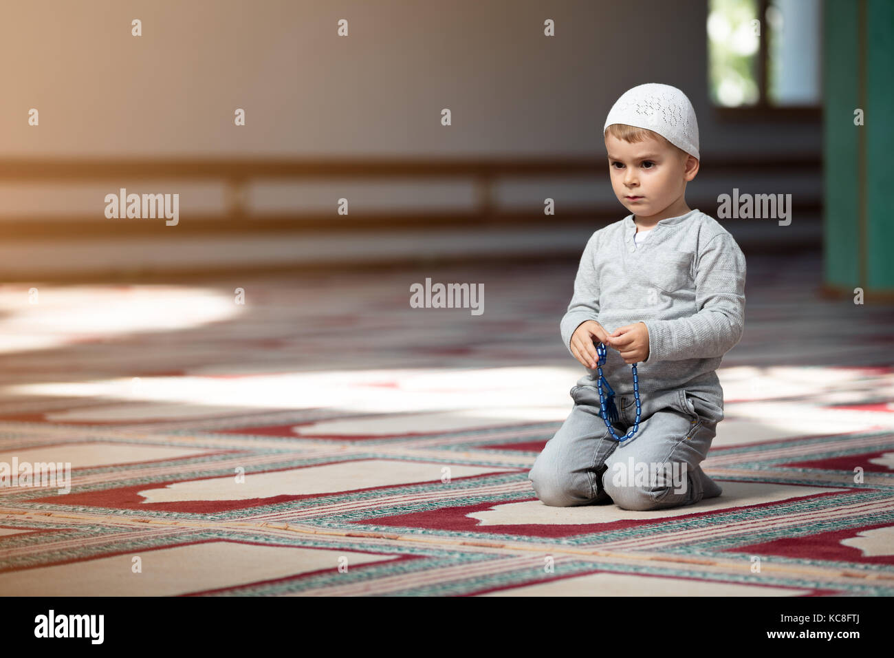 The Muslim child prays in the mosque, the little boy prays to God ...