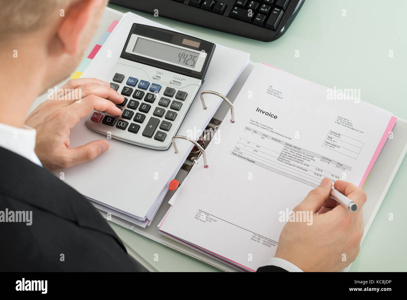 Young Businessman Calculating Tax At Office Desk Stock Photo - Alamy