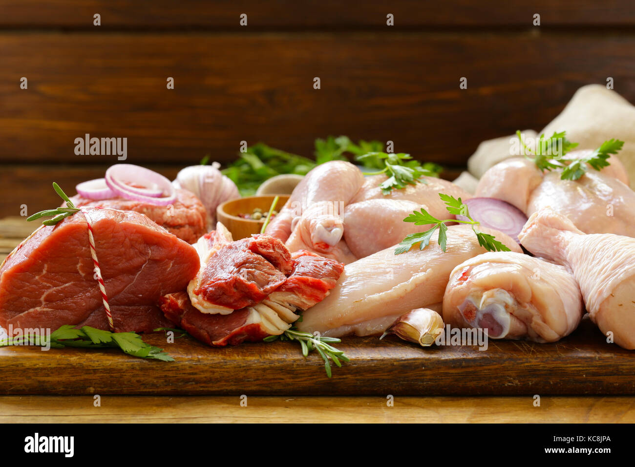 raw meat assortment - beef, lamb, chicken on a wooden board Stock Photo ...