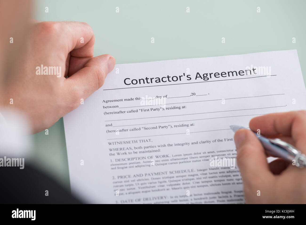 Close-up Of Person Hand Over Contractor's Agreement Form Stock Photo ...