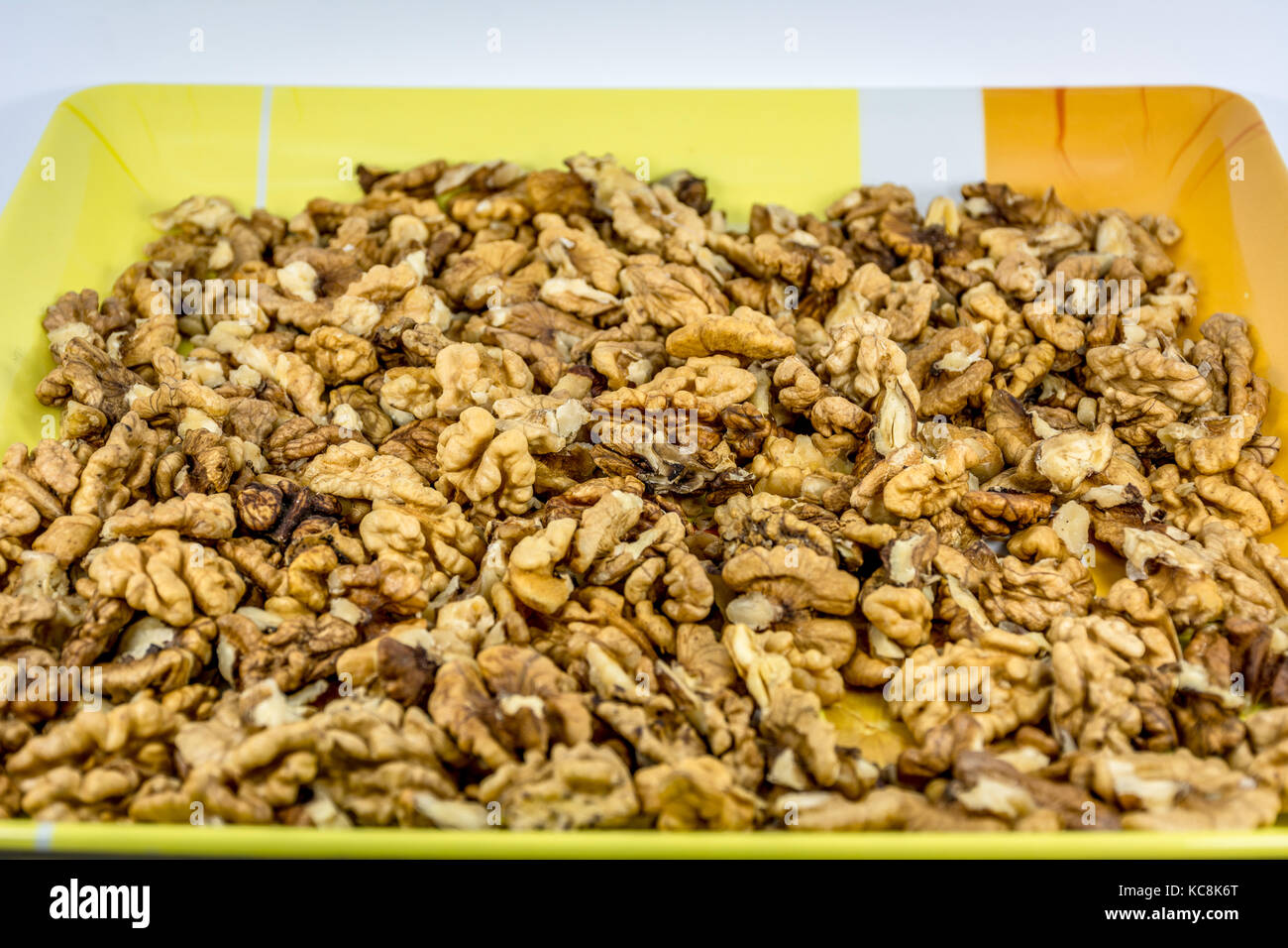 Fresh cleaned walnuts on plastic tray yellow color Stock Photo - Alamy