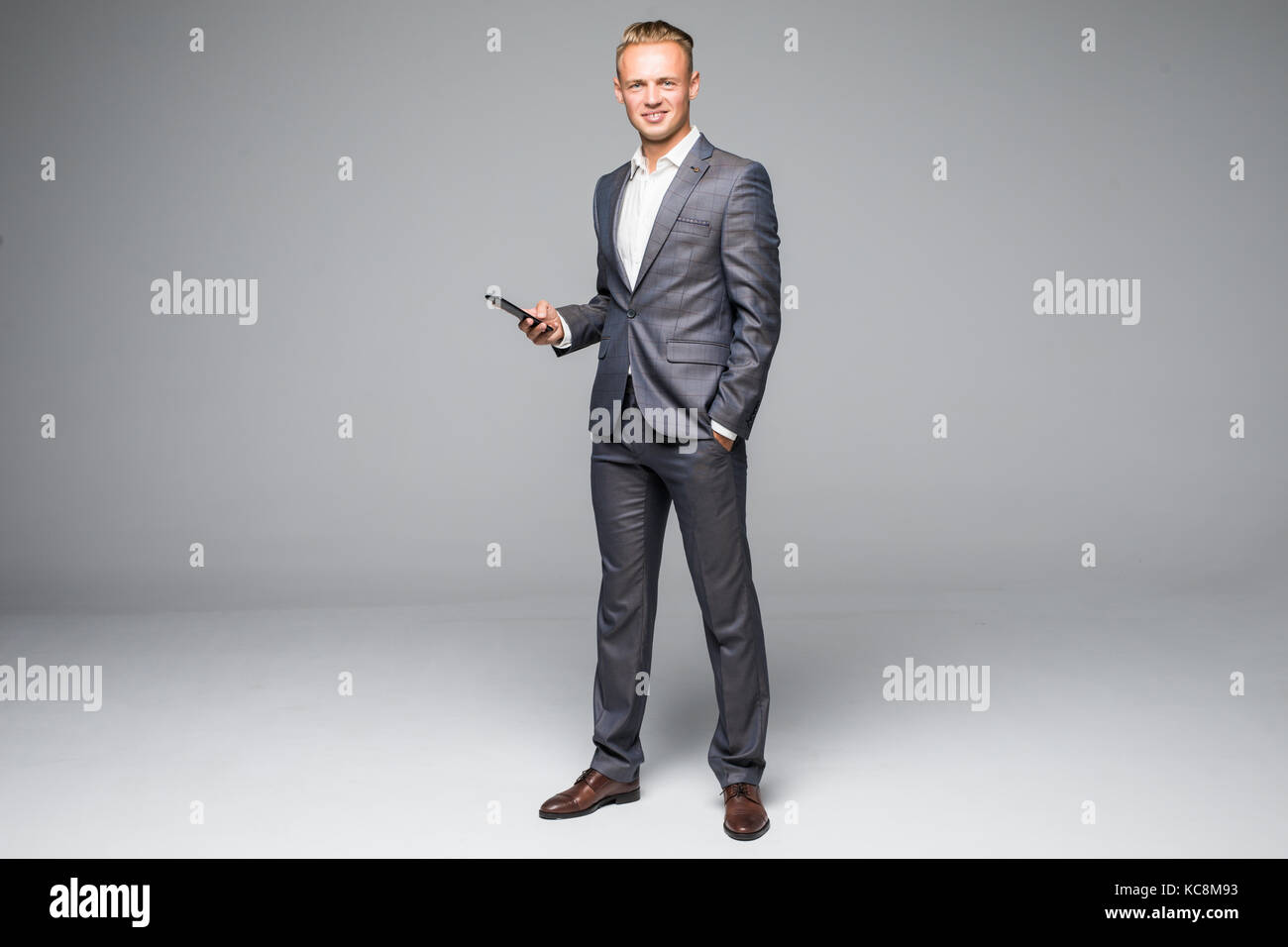 Young business man texting a message with phone over gray Stock Photo ...
