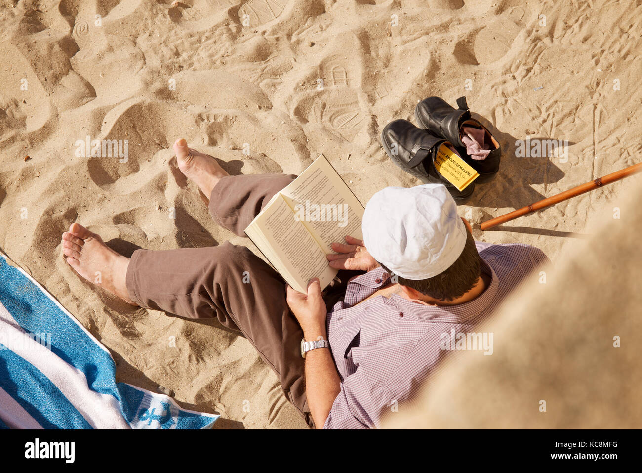 Relaxing and reading on the beach Stock Photo - Alamy