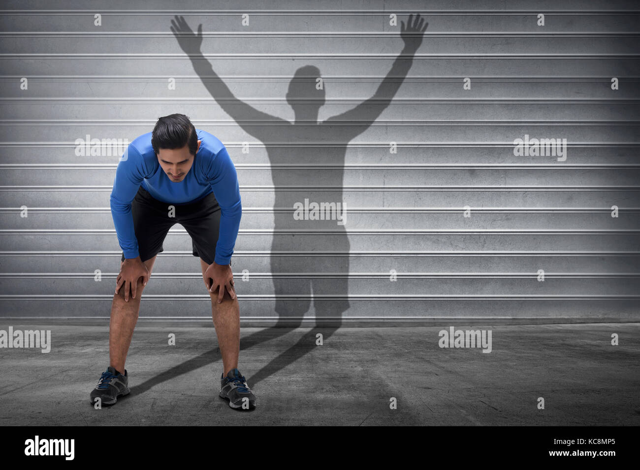 Handsome asian runner man with a shadow of spirit on metal roller ...