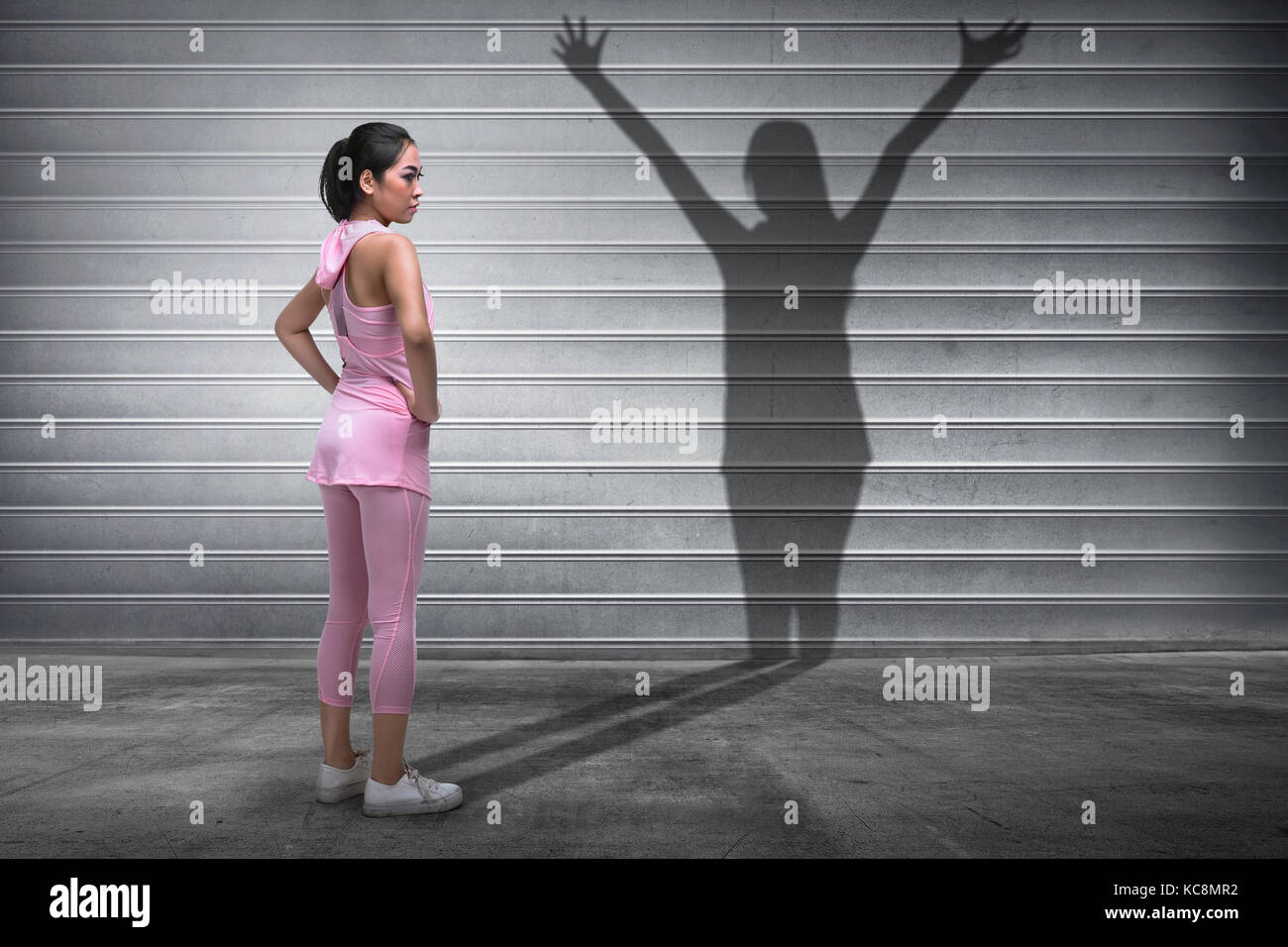 Young asian fitness woman with a shadow of spirit on metal roller ...
