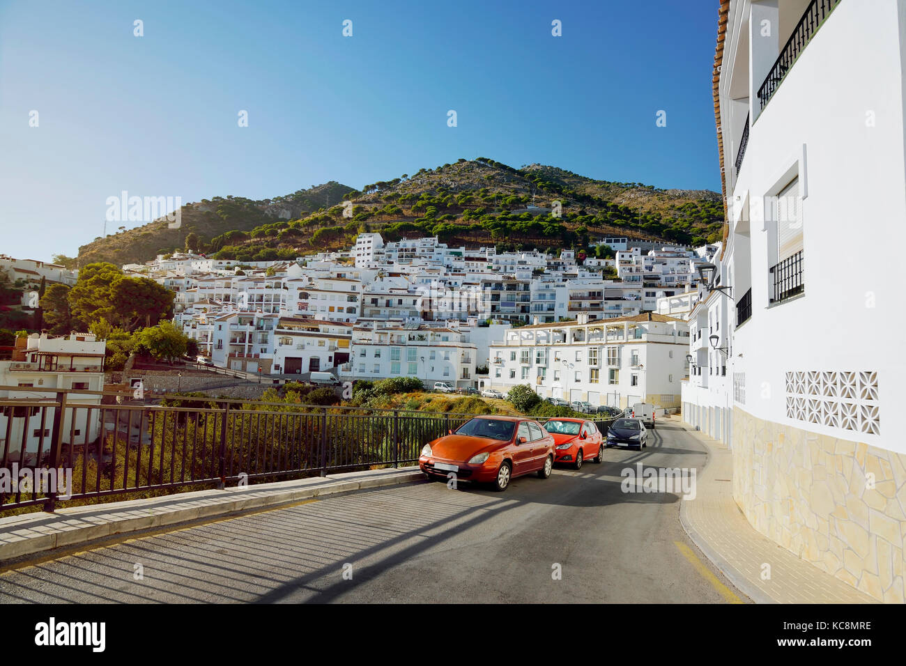 Cars parked on the roadside in the white village with blue sky ...