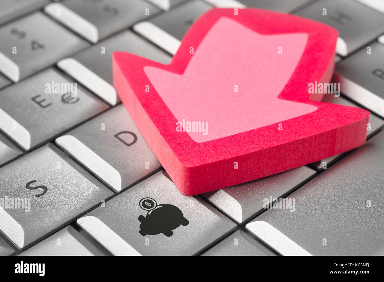 Save money. Piggy icon on a computer key. Arrow signal Stock Photo - Alamy