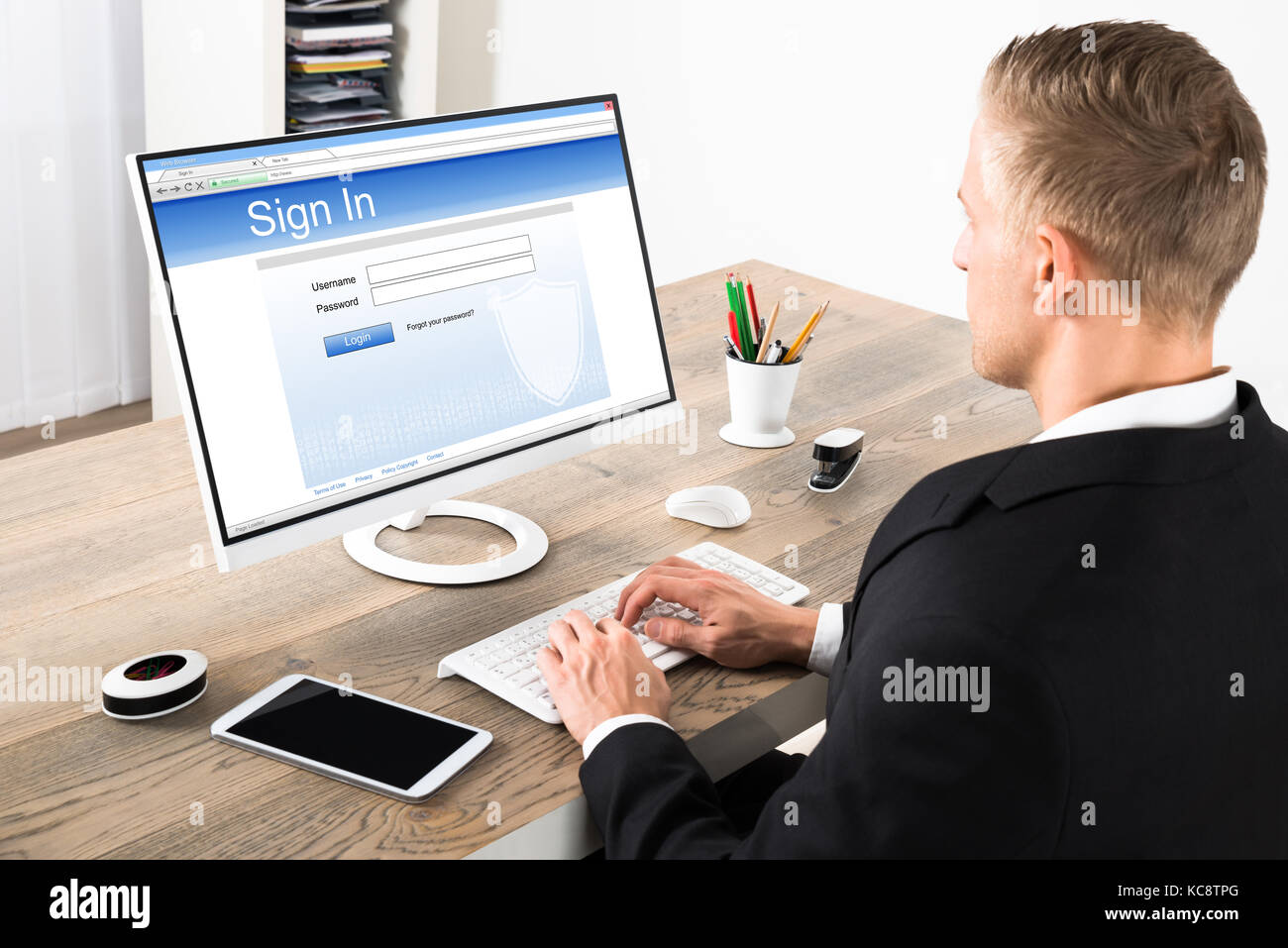 Young Businessman Signing Into A Website On Computer At Office Stock ...