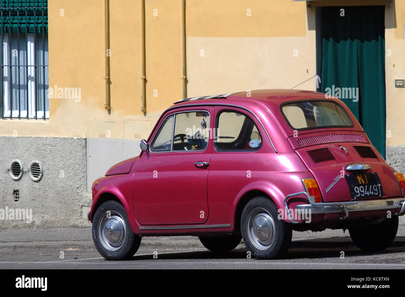 Pink purple Fiat 500 parked on the street. Classic vintage model ...