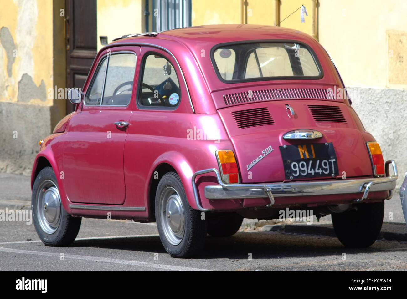 Pink purple Fiat 500 parked on the street. Classic vintage model ...