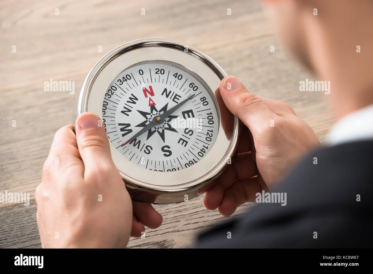 Close-up Of Young Businessman Holding Compass At Desk In Office Stock ...