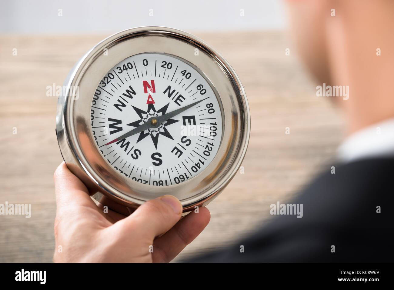 Close-up Of Young Businessman Holding Compass At Desk In Office Stock ...