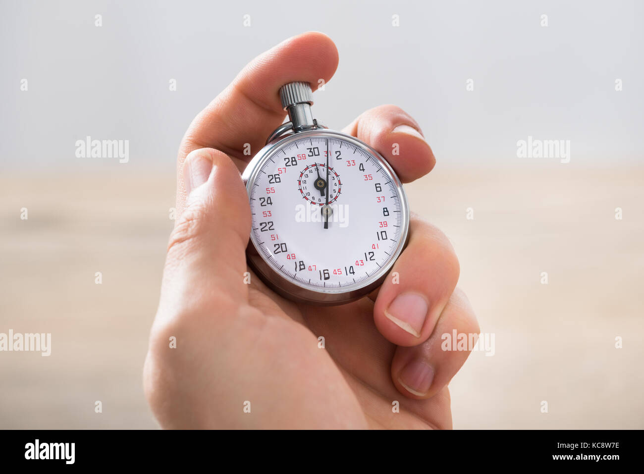 Close-up Of Businessman Holding Stopwatch In Office Stock Photo - Alamy