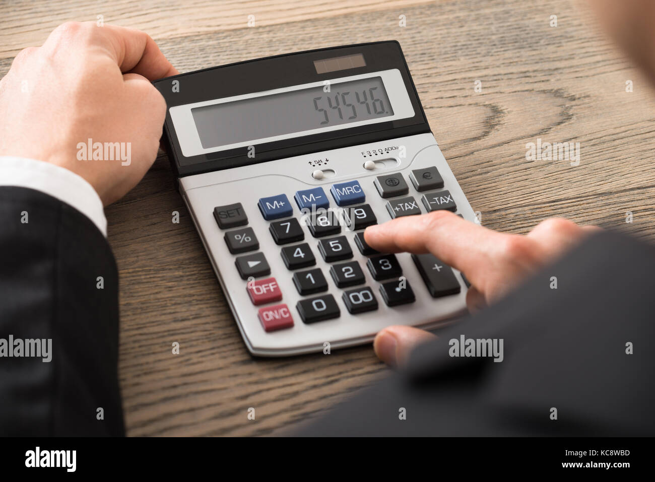Close-up Of A Businessman Using Calculator At Desk In Office Stock ...