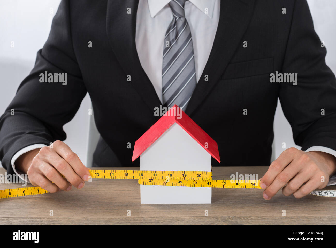 Close-up Of Businessman Hand Measuring House Model At Wooden Desk Stock ...