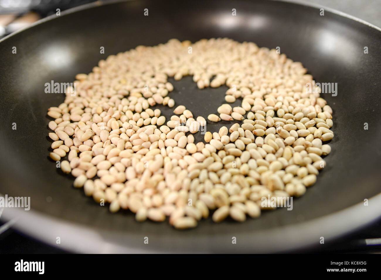 Pine nut kernels being roasted in a frying pan Stock Photo - Alamy