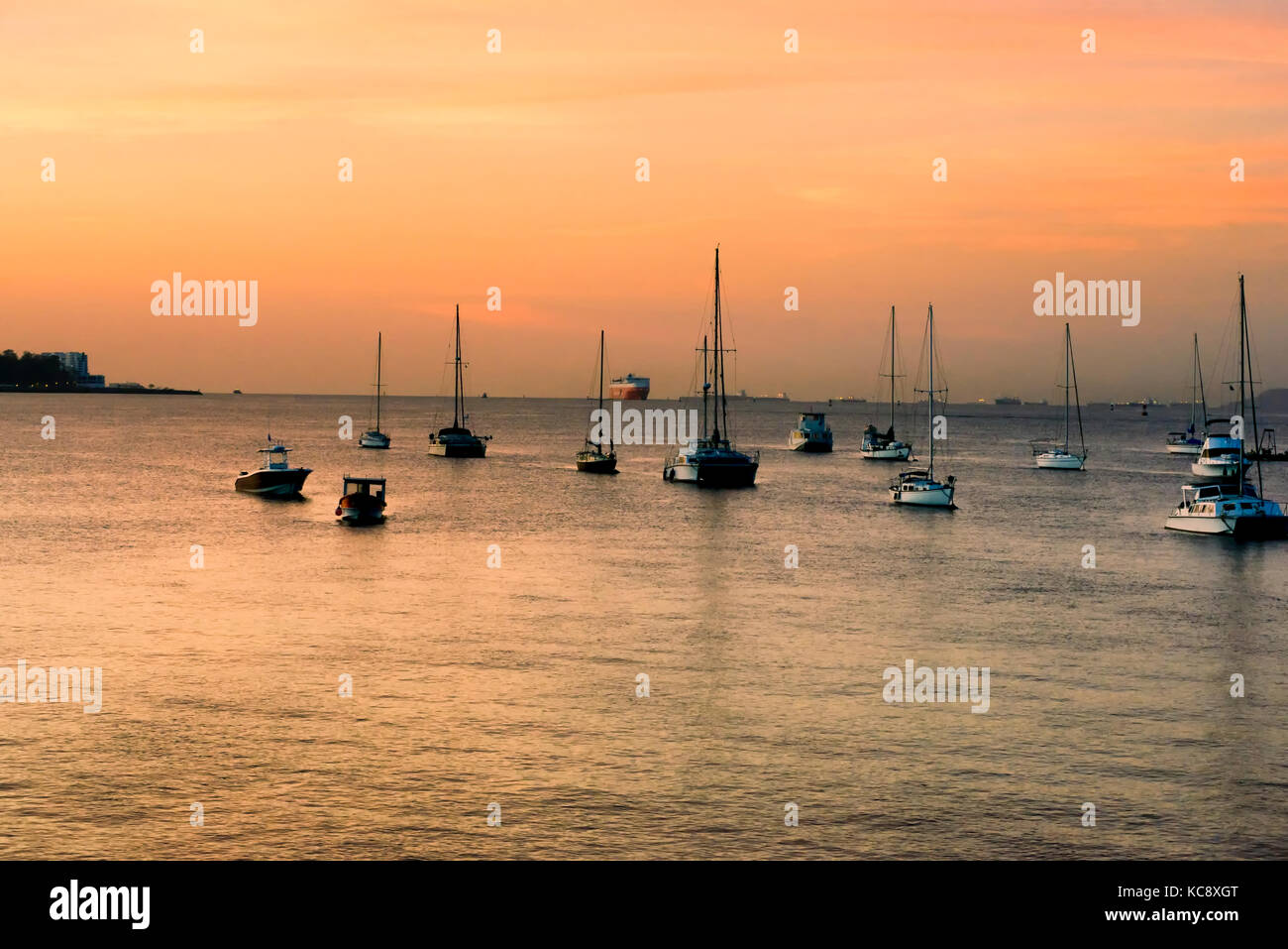 Sunrise over Panama Canal. Small boats moored and at far end ships ...