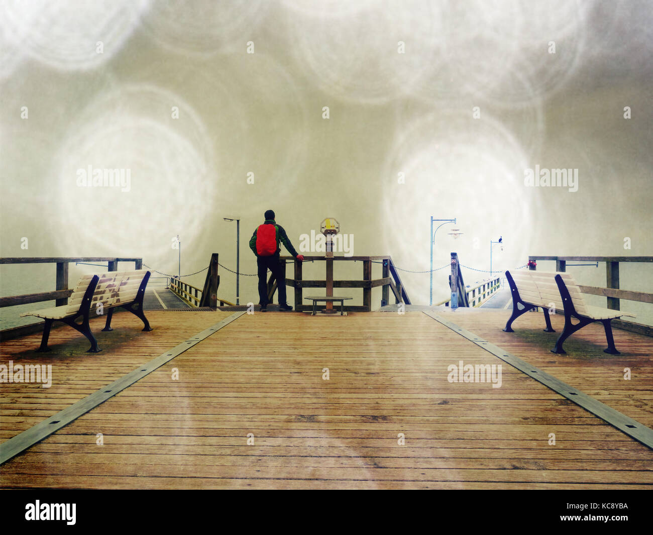 Lens defect. Man on long touristic mole, autumn cold morning. Tourist ...