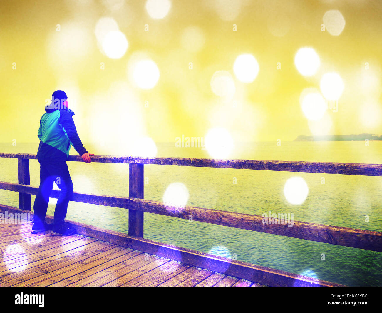 Lens defect. Man on long touristic mole, autumn cold morning. Tourist ...