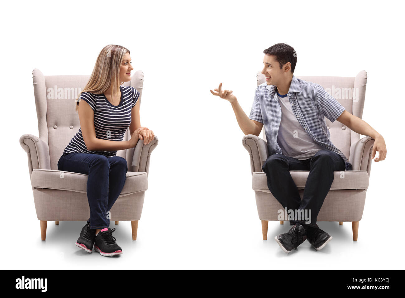 Young woman and a young man sitting in armchairs and talking isolated ...