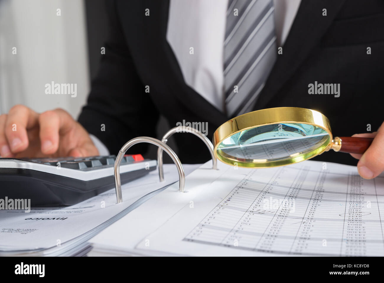 Close-up Of Young Businessman Checking Invoice With Magnifying Glass At ...
