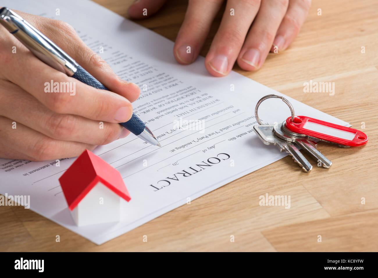 Close-up Of Businessman Filling Contract Form With Key And House Model ...
