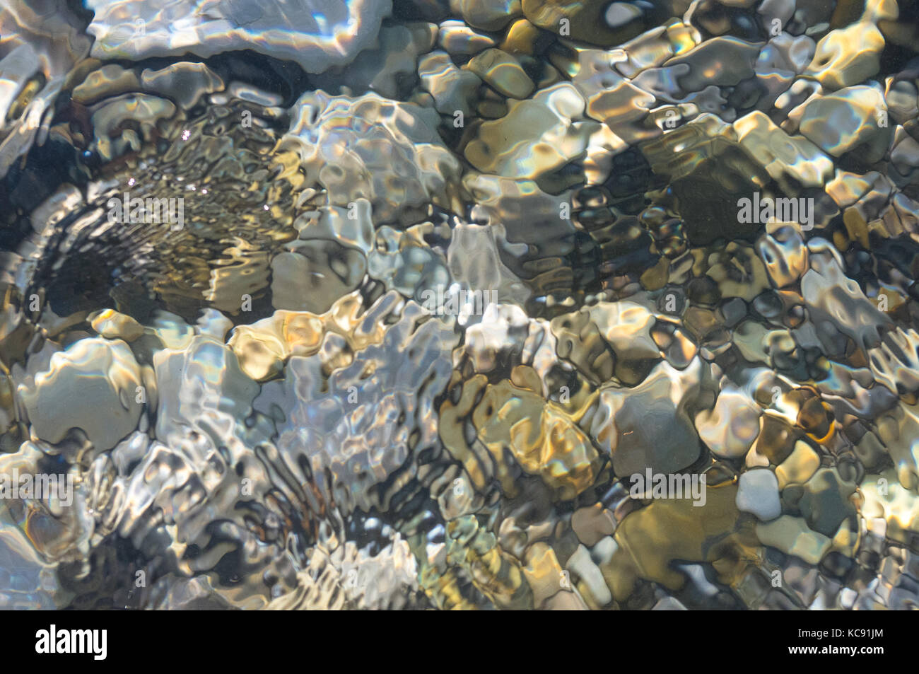 sea pebble beach with multicoloured stones, transparent waves with foam ...