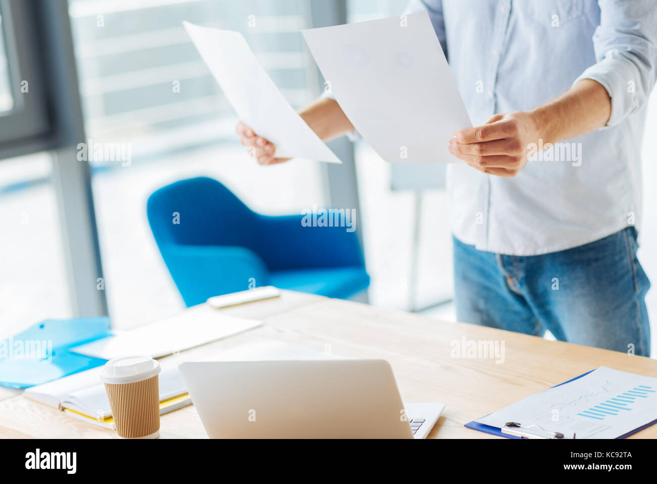 Attentive man checking both documents Stock Photo - Alamy