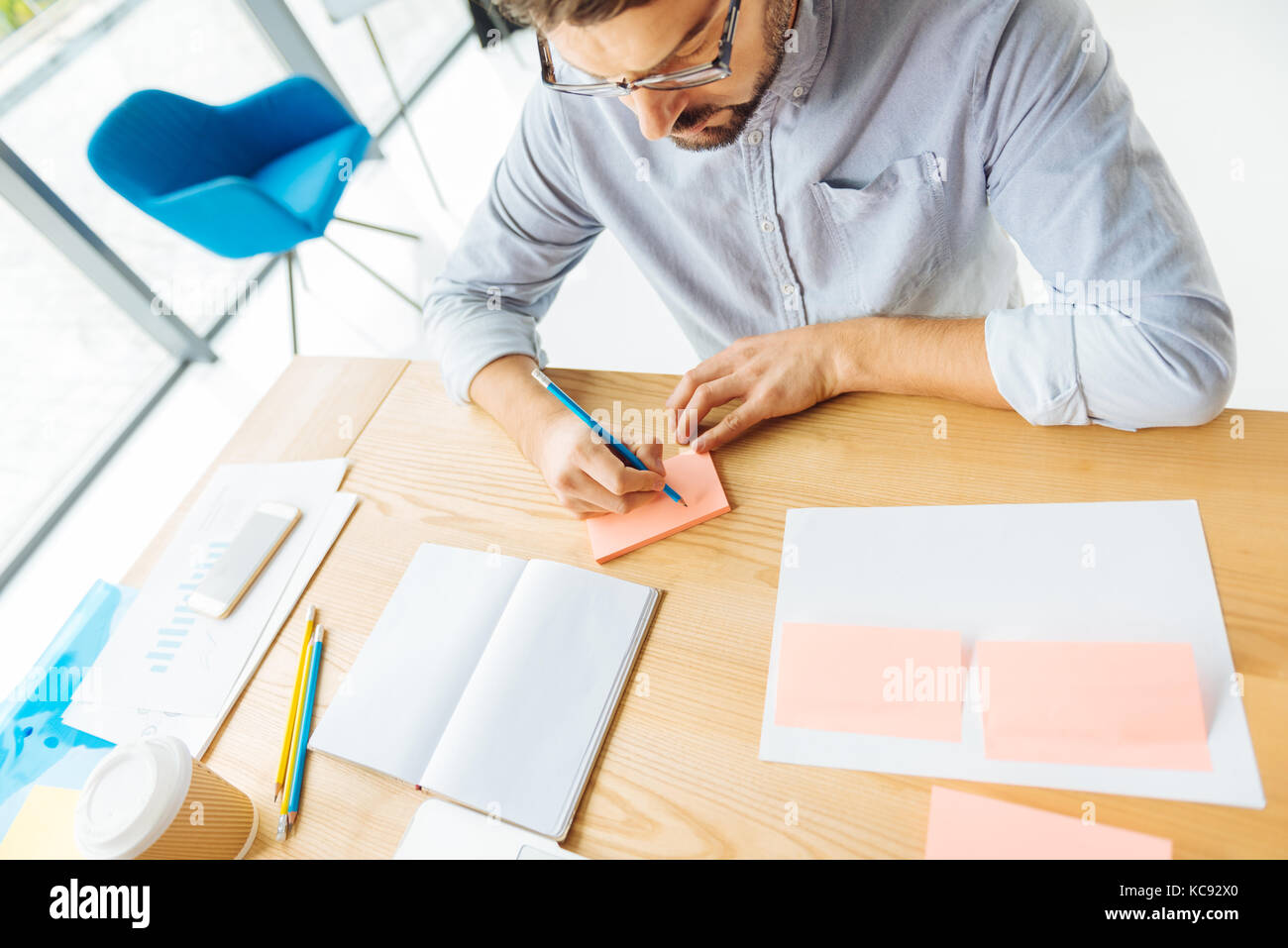 Attentive office worker writing notes Stock Photo - Alamy