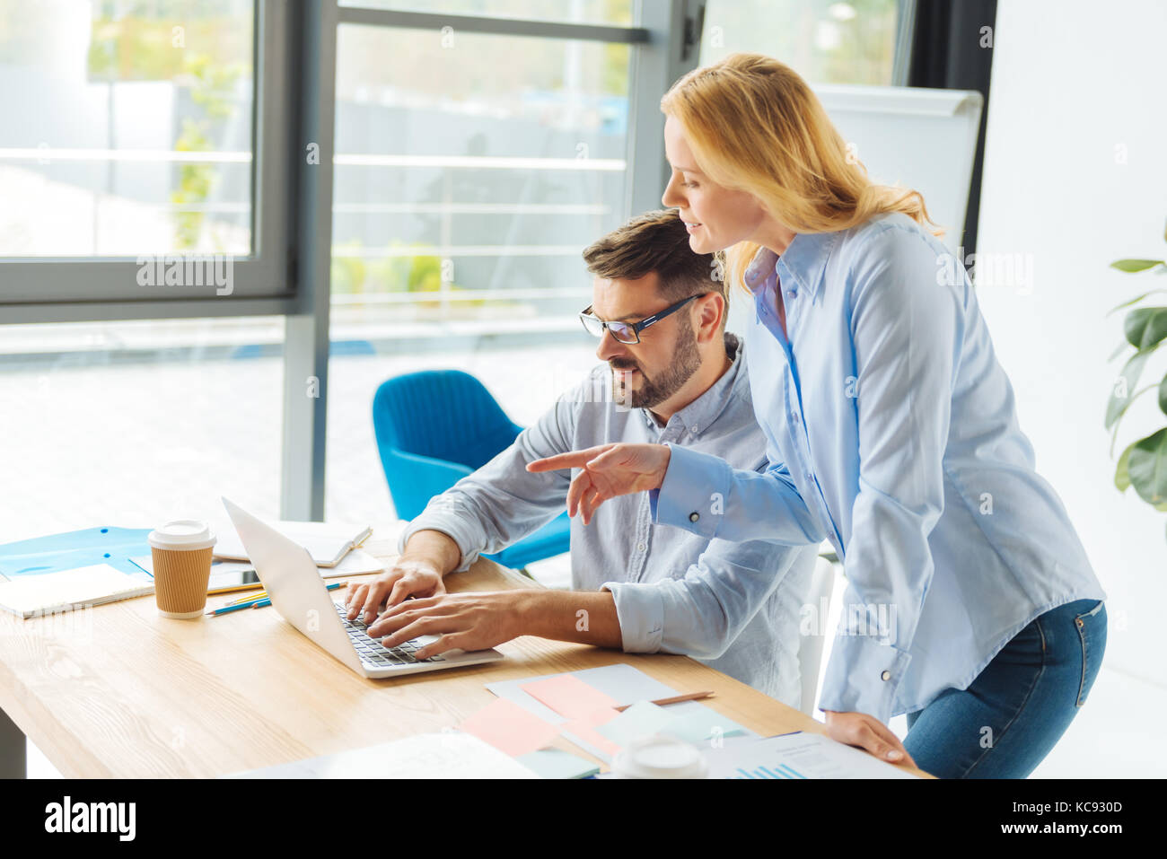 Friendly colleagues discussing their project Stock Photo - Alamy