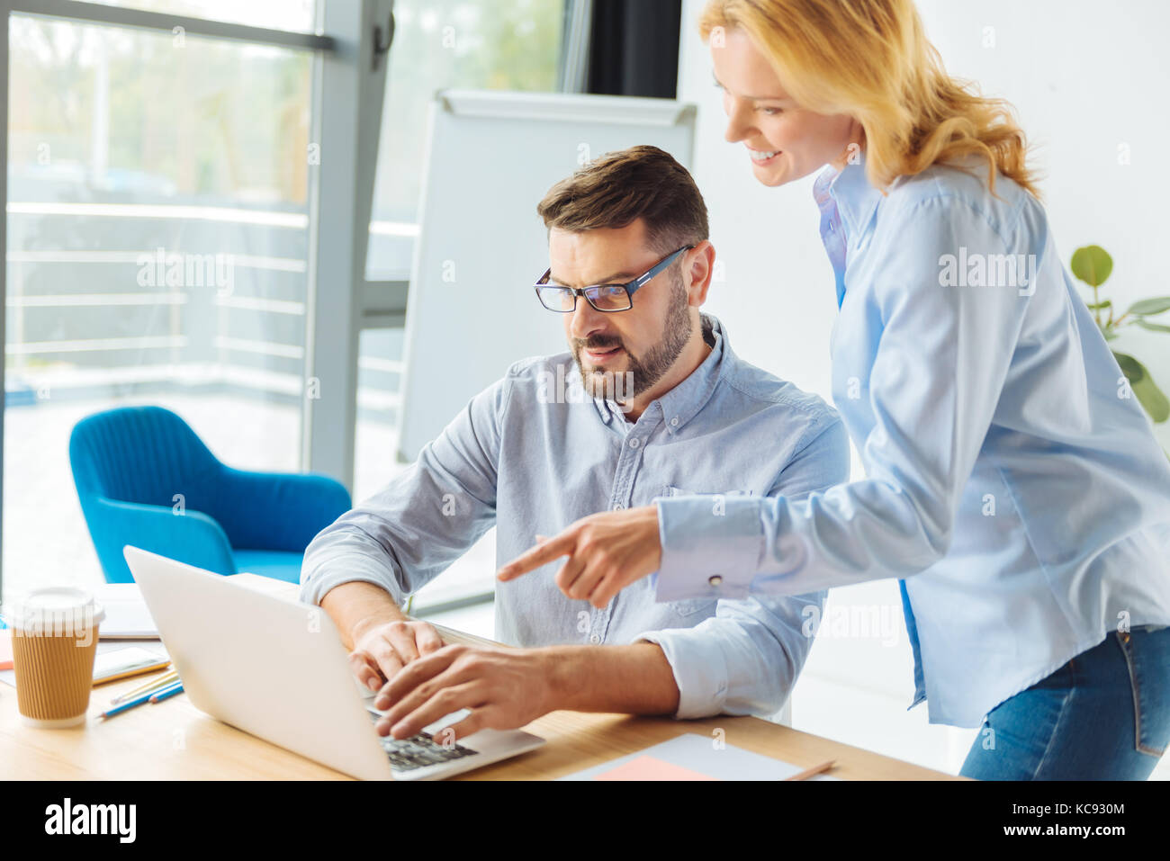 Concentrated man helping his colleague Stock Photo - Alamy