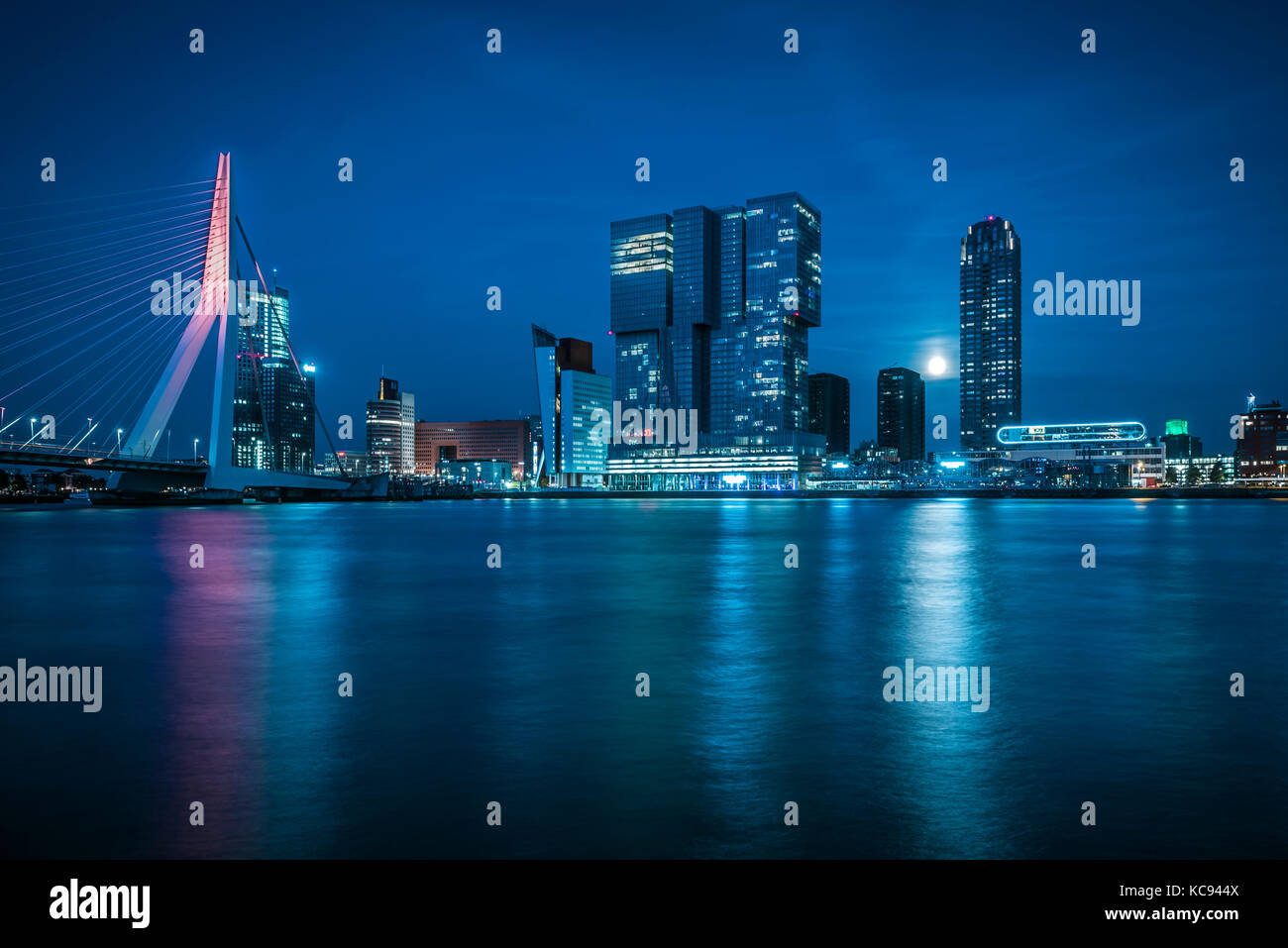 Rotterdam city centre at night with moon. Mass river and Erasmus Bridge ...
