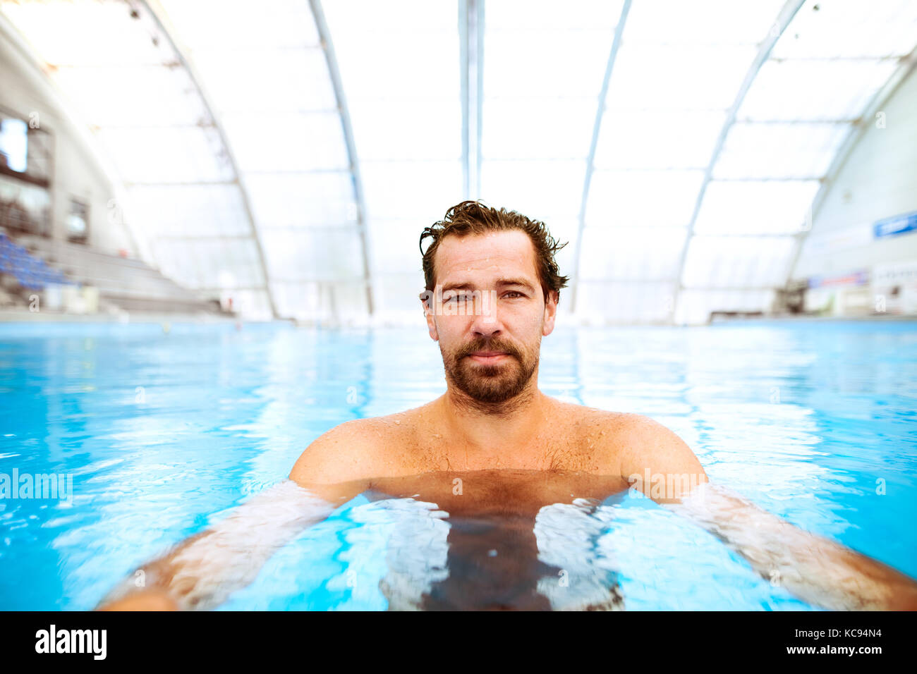 Young man swimming in indoor swimming pool. Man doing sport Stock Photo ...