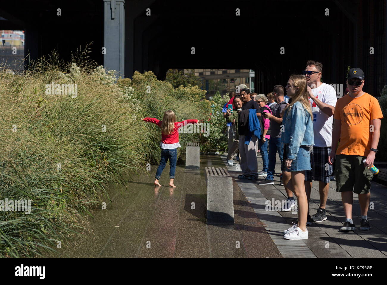 Pedestrians walk along the High Line in New York, New York on October ...