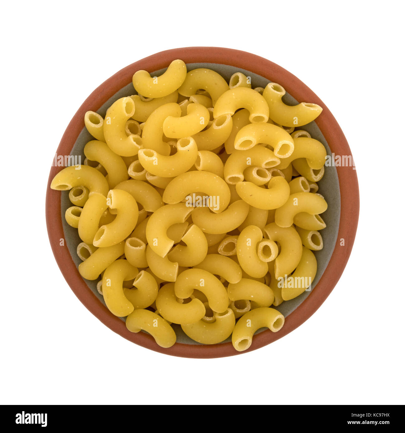 Top view of yellow elbow macaroni in a small terra cotta bowl isolated ...