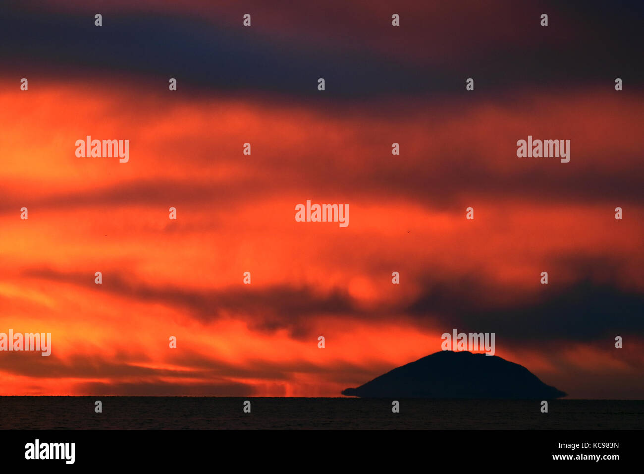 Sunrise over an island Stock Photo - Alamy