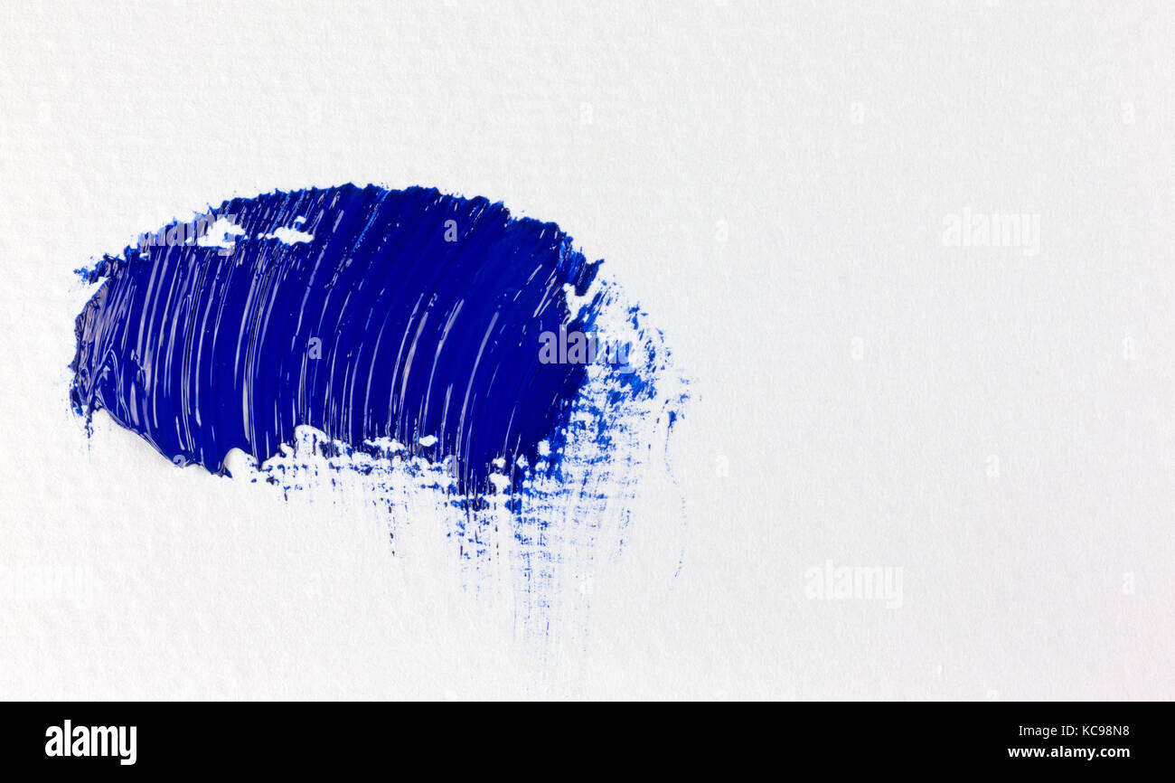 A splotch of blue acrylic paint on a white heavyweight artist paper ...